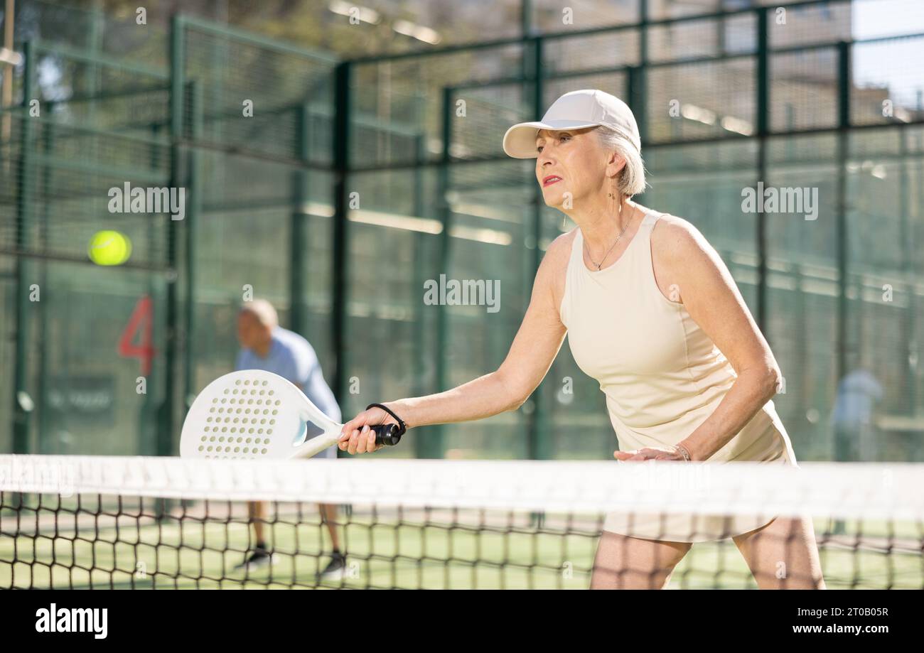 Old woman playing Padel Tennis in open-air tennis court Stock Photo - Alamy