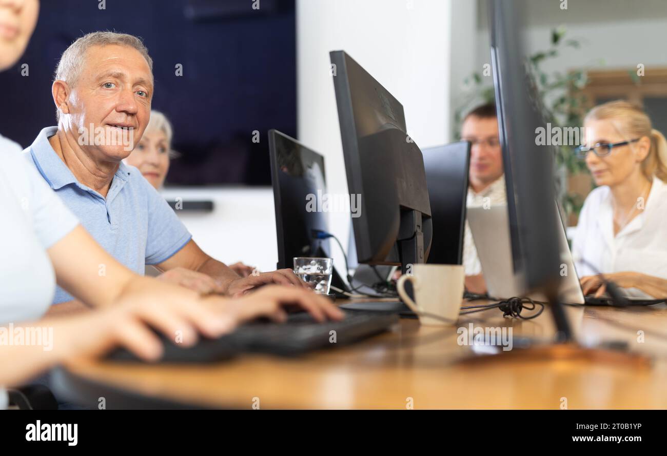 Old man learning computer programs in training room Stock Photo - Alamy