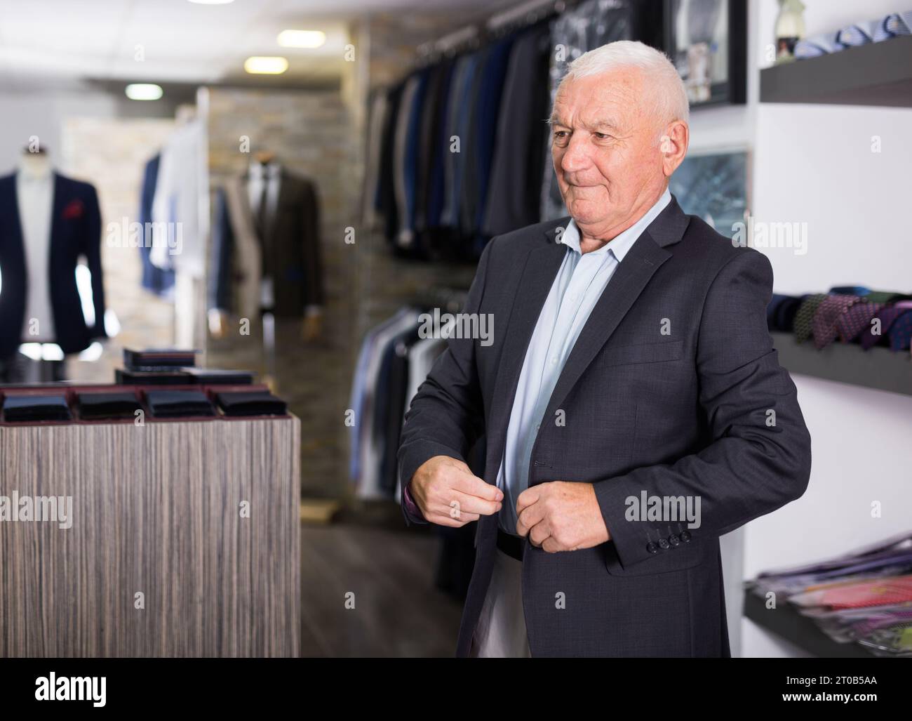 Mature male shopper shows off his jacket at men's store Stock Photo - Alamy