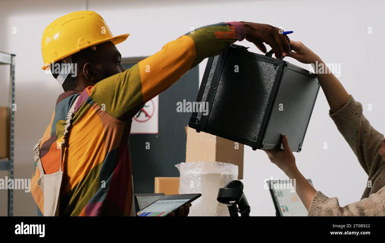 Diverse people checking computer list with orders, reviewing packages ...