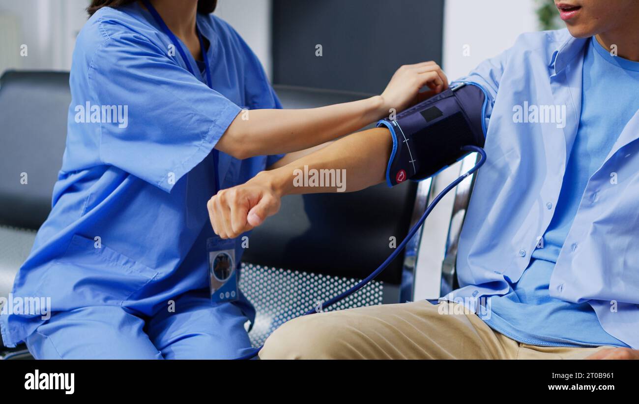 Asian nurse checking patient hypertension using medical tonometer ...