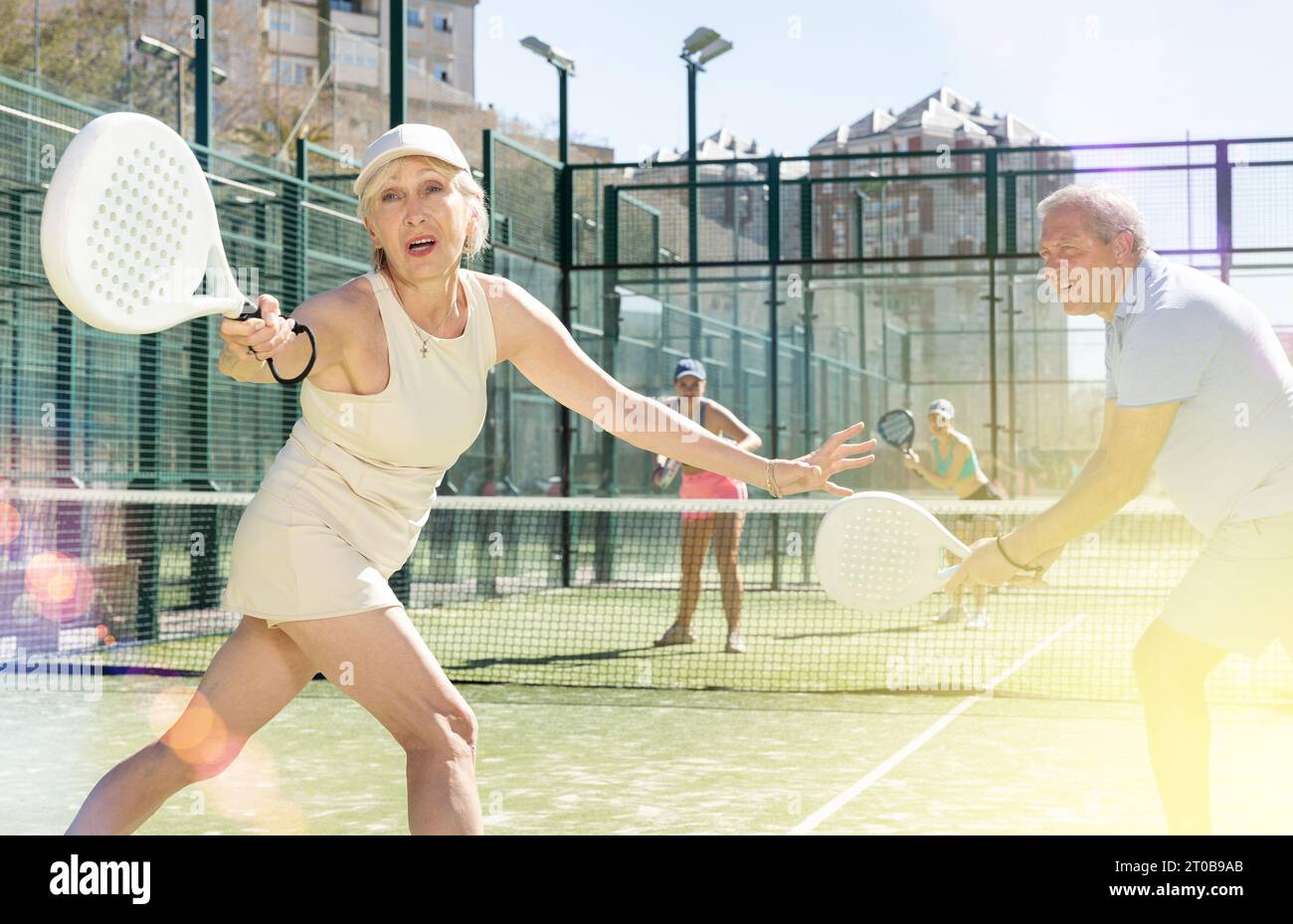 Motivated senior woman playing padel with her teammate in court Stock ...
