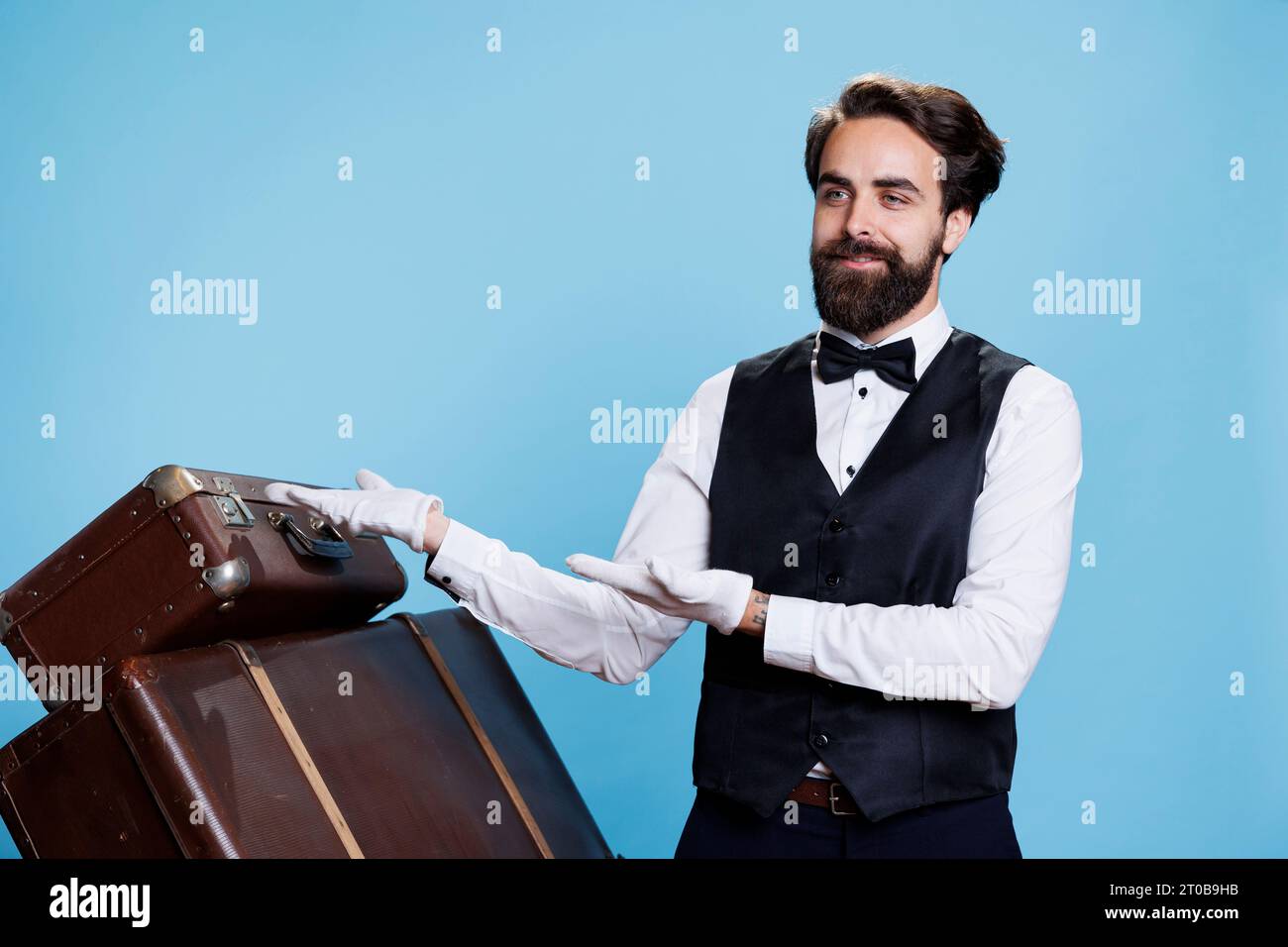 Young bellboy presents directions in studio, point to left and right ...