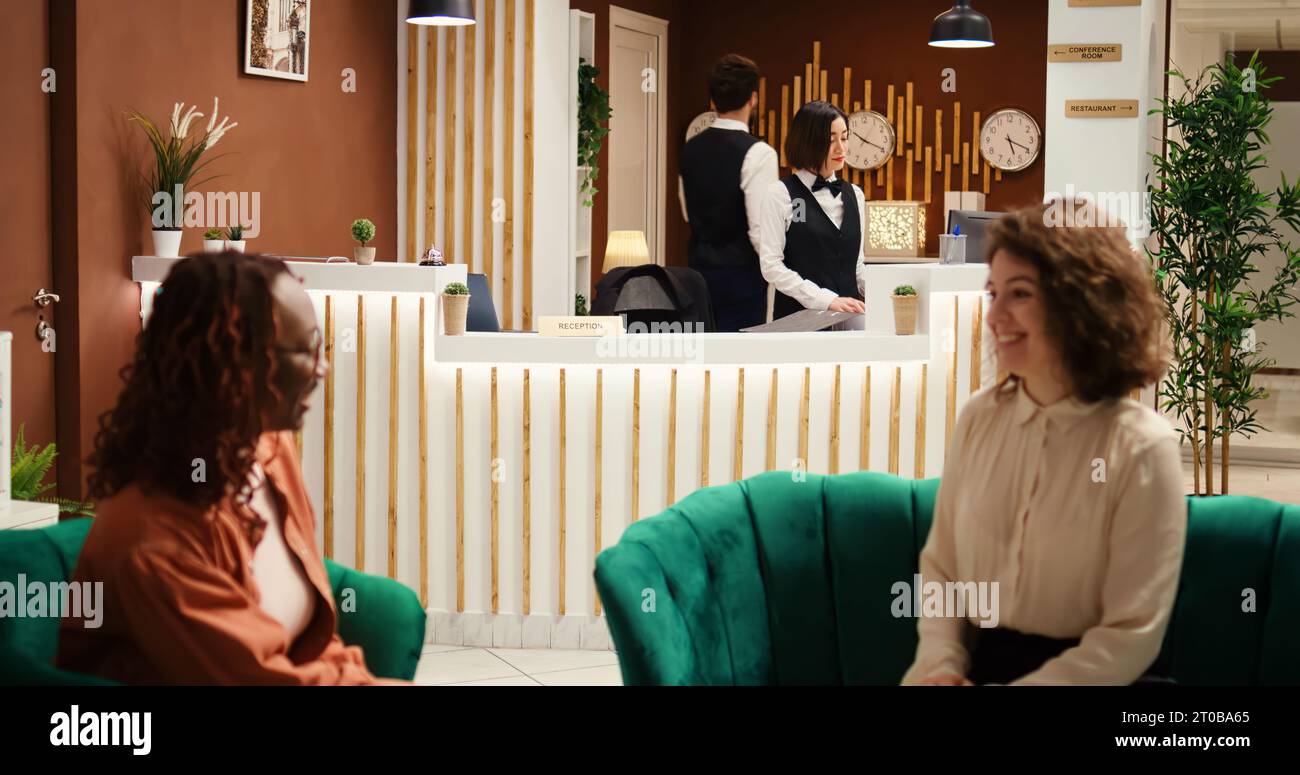 Hotel personnel checking guest booking details, preparing guest room ...