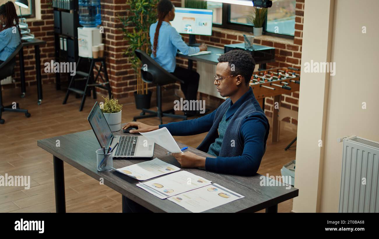 Corporate worker reviewing paperwork in office, looking at documents ...