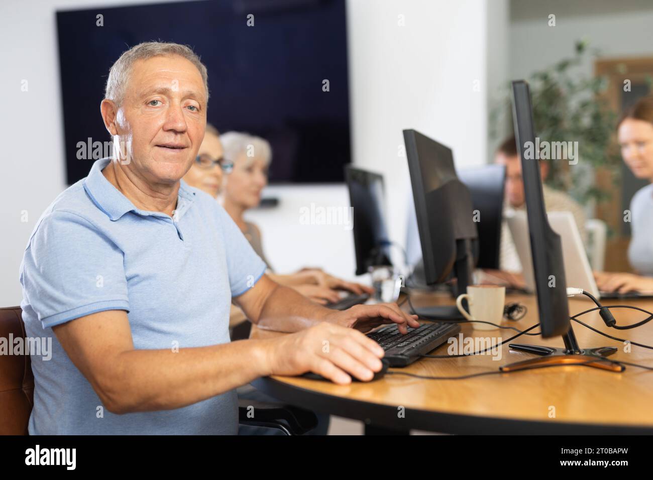 Old man learning computer programs in training room Stock Photo - Alamy
