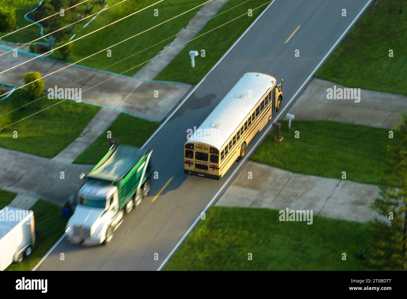 Aerial view of american yellow school bus driving on suburban street ...
