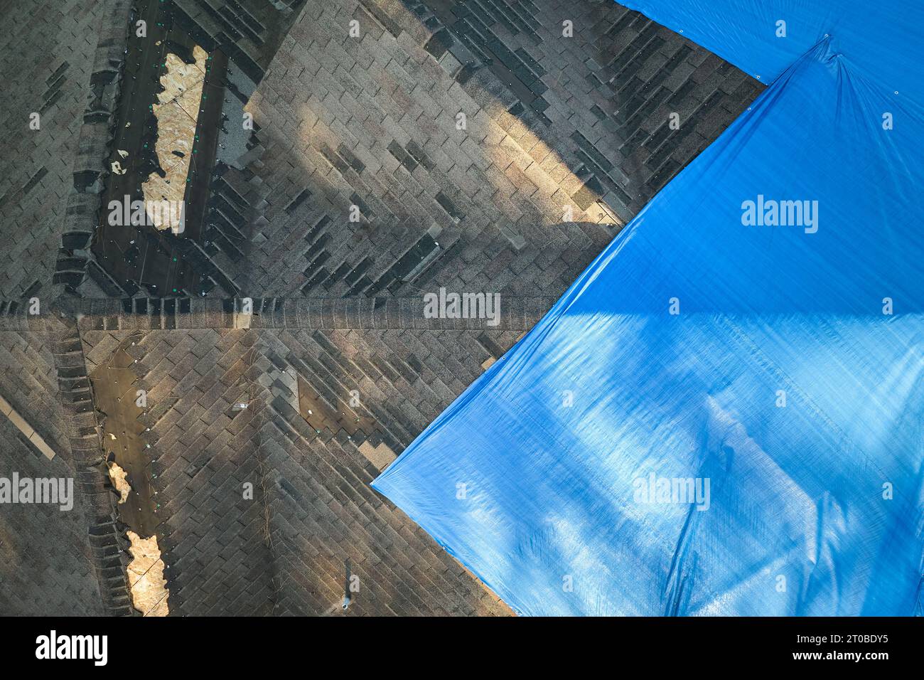 Aerial view of damaged in hurricane Ian house roof covered with blue ...