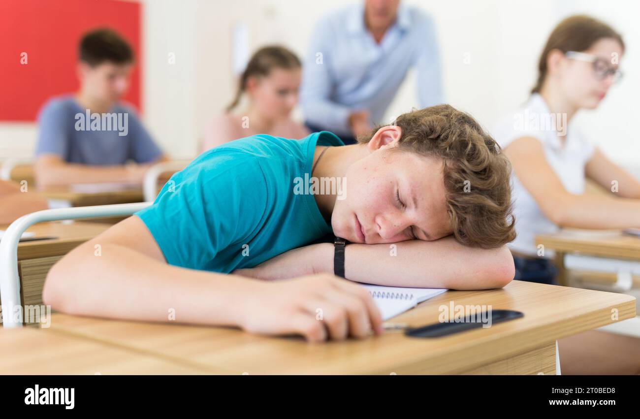 Tired teen student sleeping at desk during lesson Stock Photo - Alamy