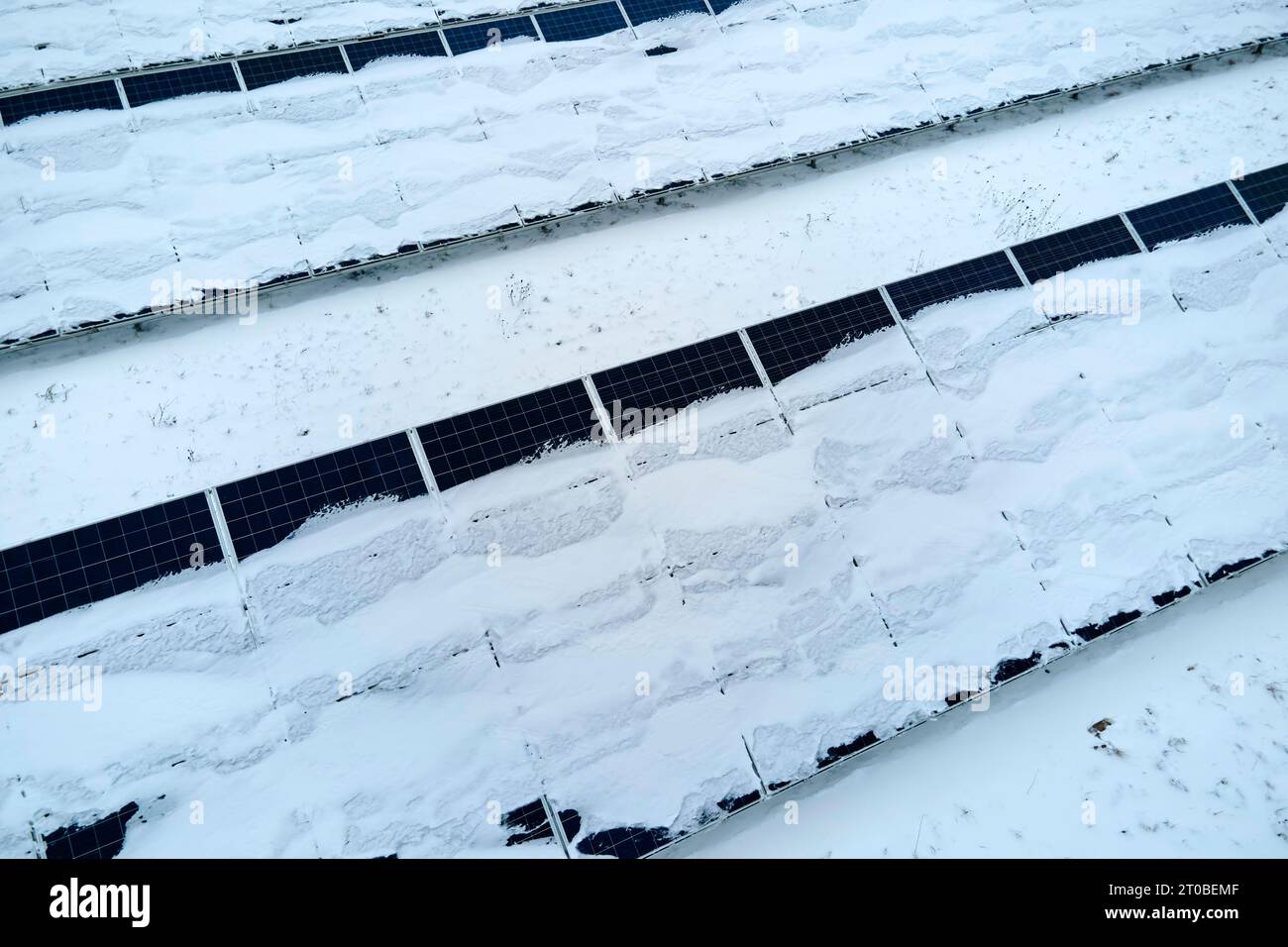 Aerial view of snow covered sustainable electric power plant with rows ...