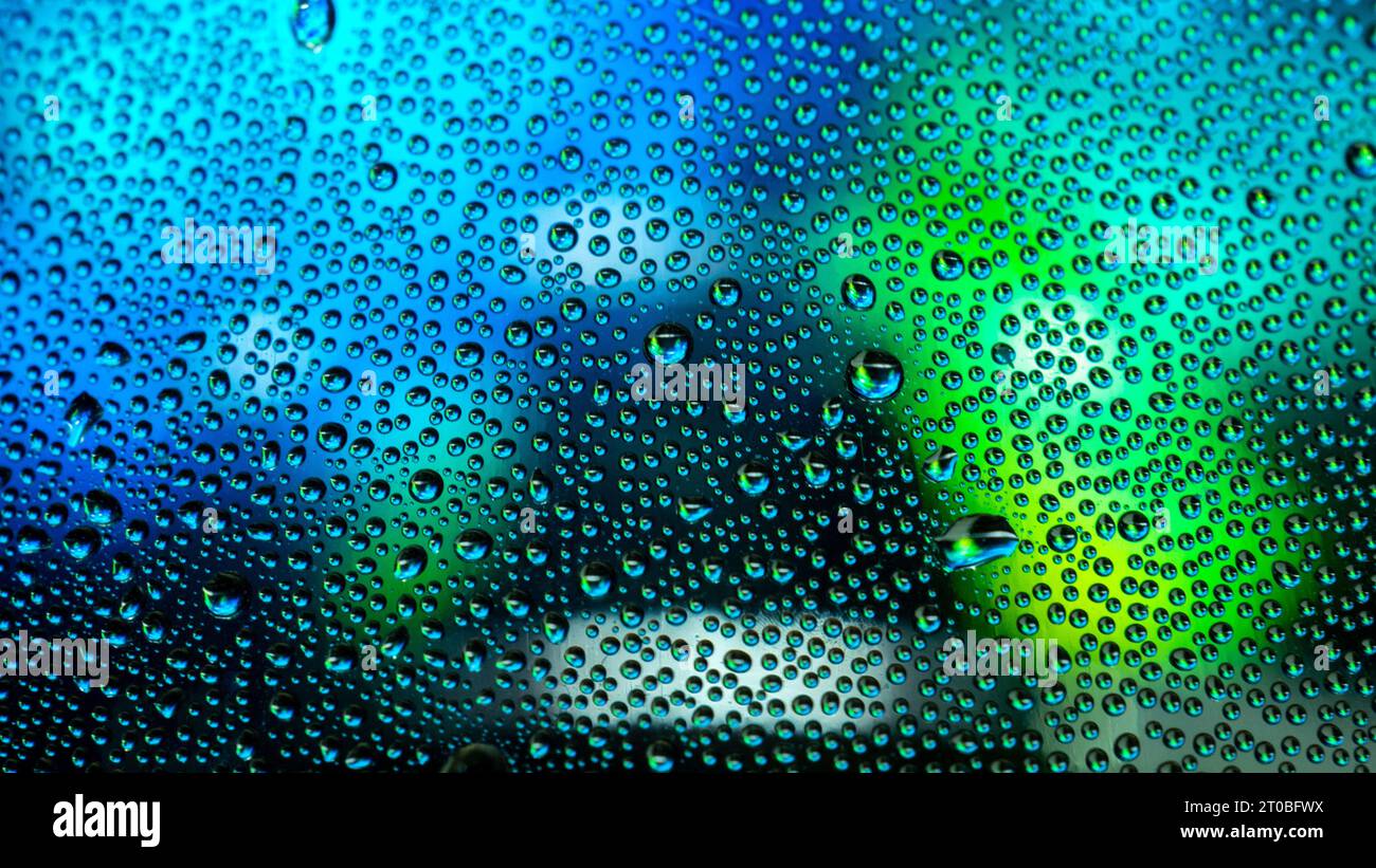 Macro of water drops over a colorful green and blue gradient background ...