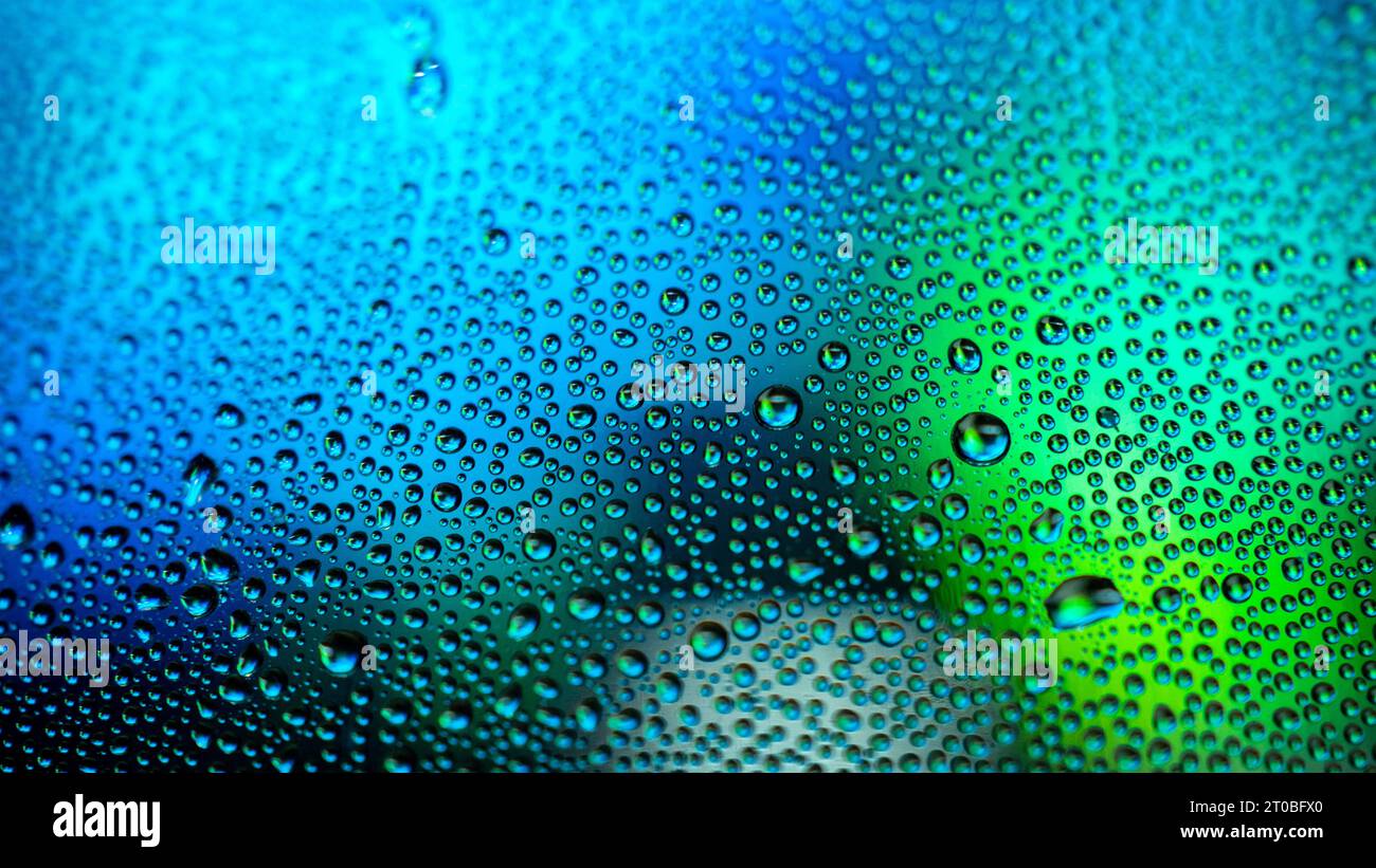 Macro of water drops over a colorful green and blue gradient background ...