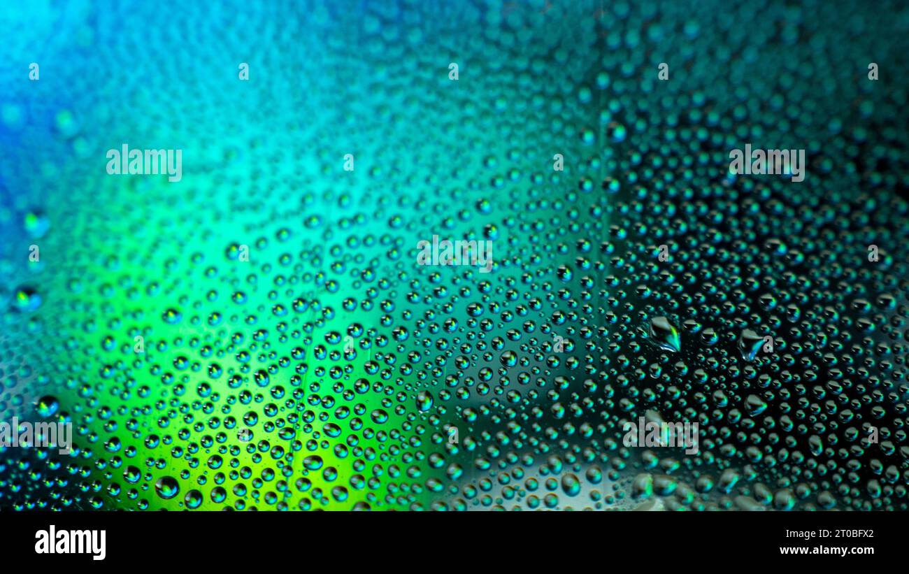Macro of water drops over a colorful green and blue gradient background ...