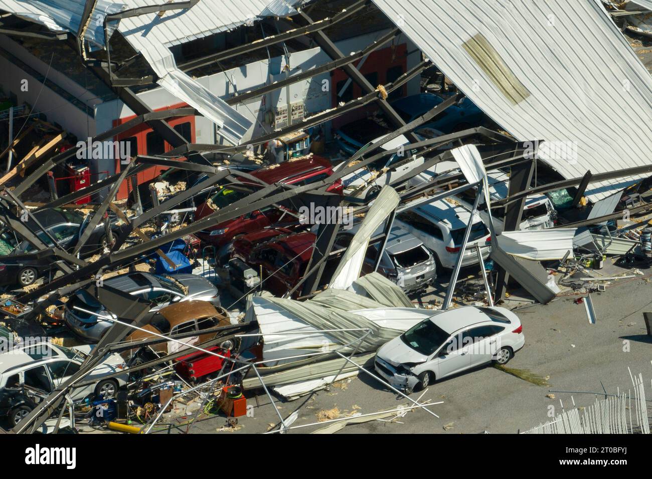 Automotive workshop destroyed by hurricane wind with damaged cars under ...