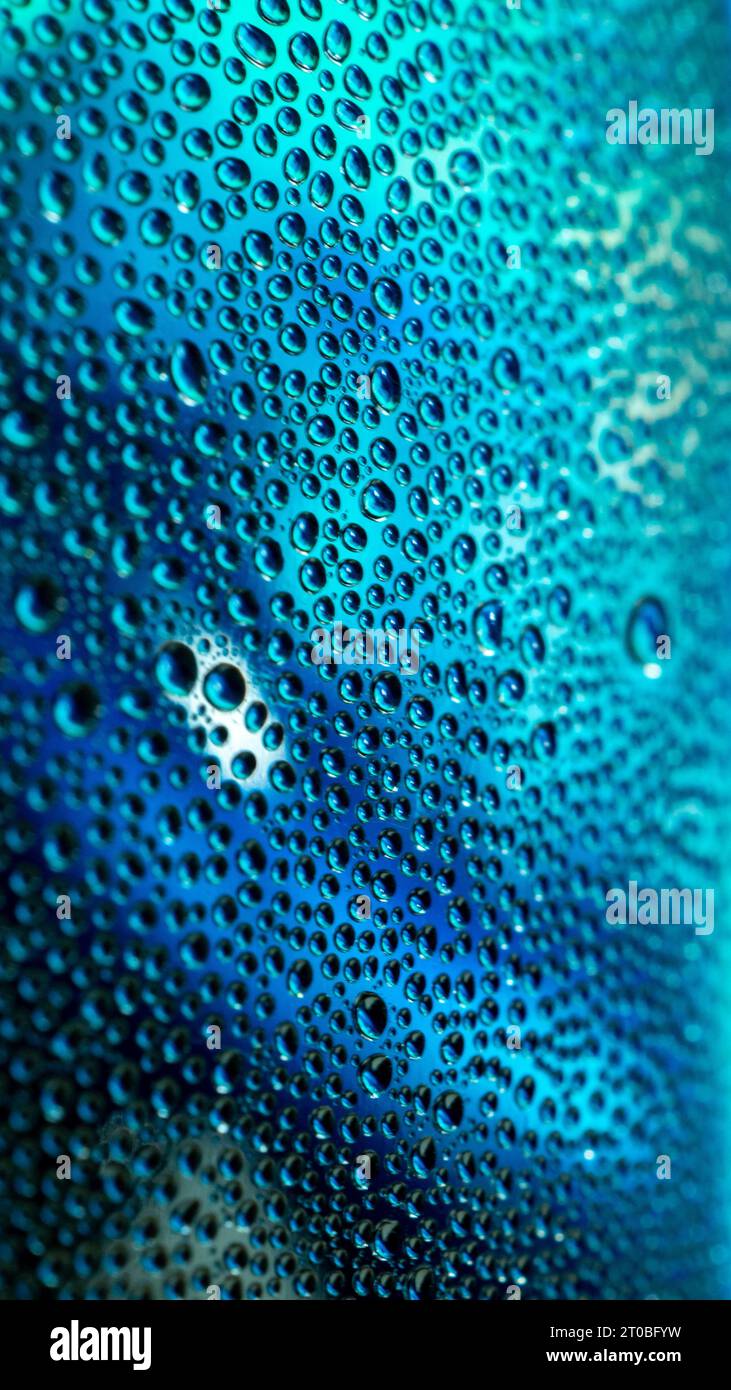 Macro of water drops over a colorful green and blue gradient background ...