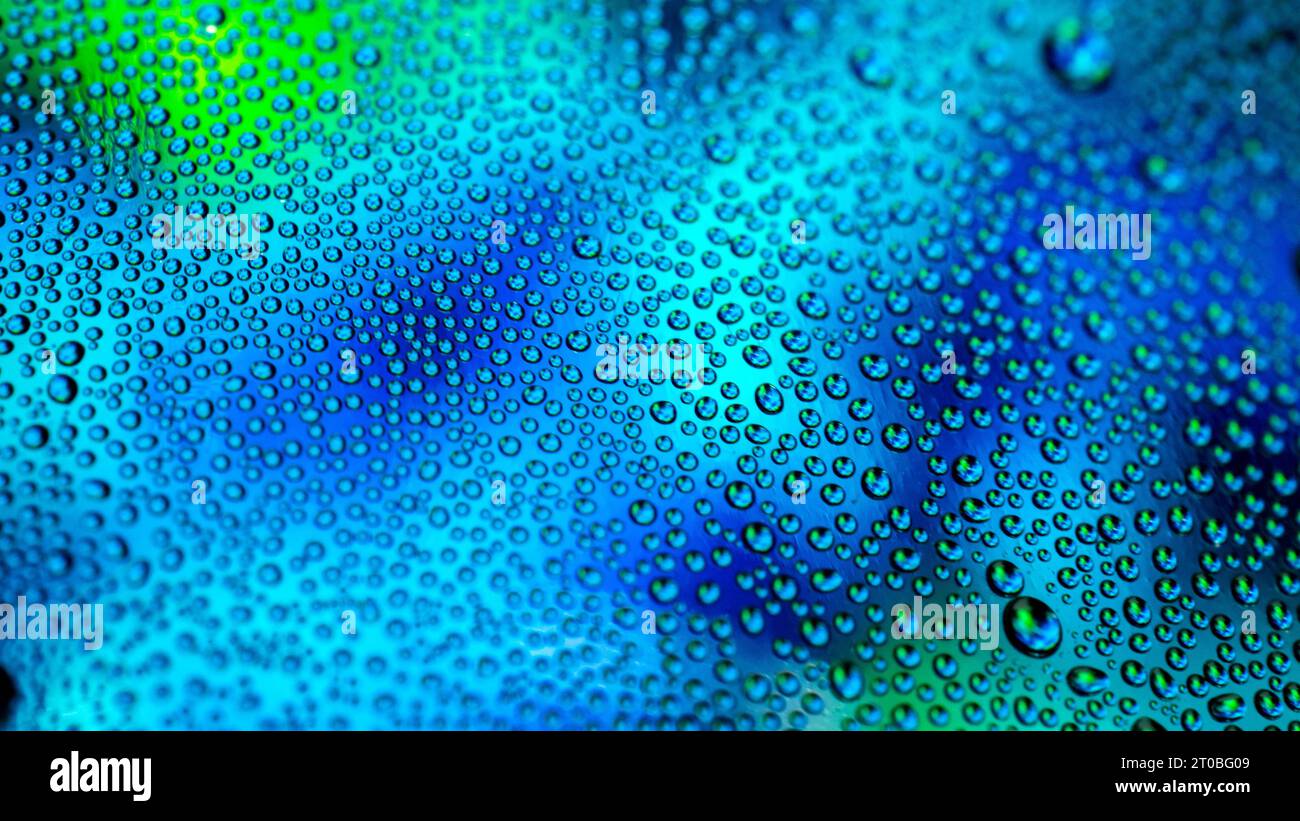 Macro of water drops over a colorful green and blue gradient background ...