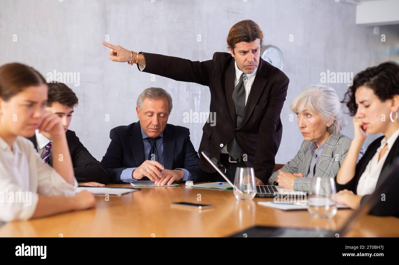 Portrait of angry male boss in business suit pointing to the door to ...
