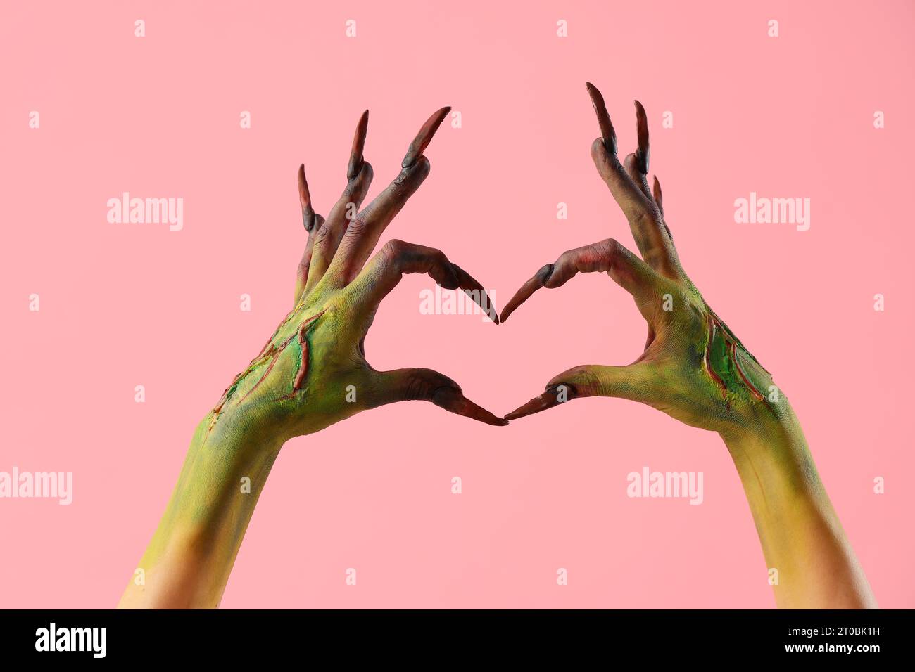 Witch with claws making heart gesture on pink background. Halloween ...