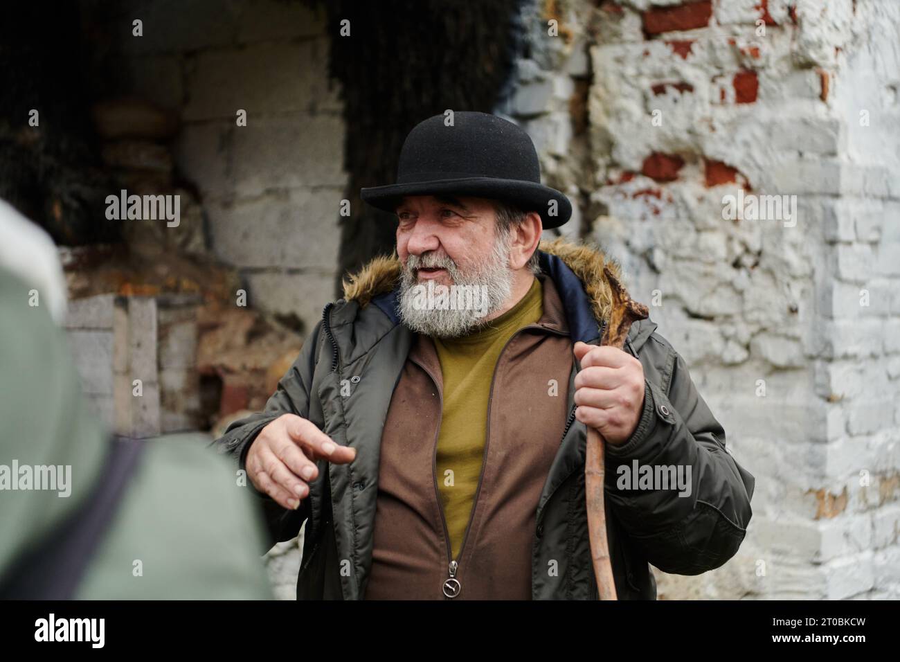 An elderly man with a beard and a worn hat passionately imparts ...