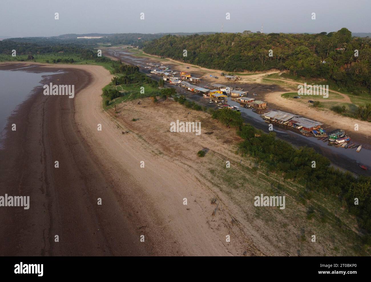 Floating homes and boats lay stranded on the dry bed of Puraquequara ...