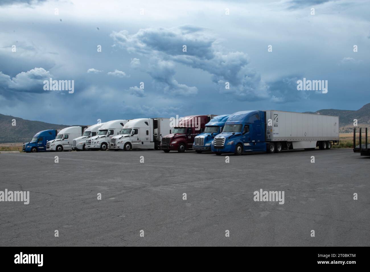Seven 18-wheelers, semi-trucks, were parked in a resing station for ...