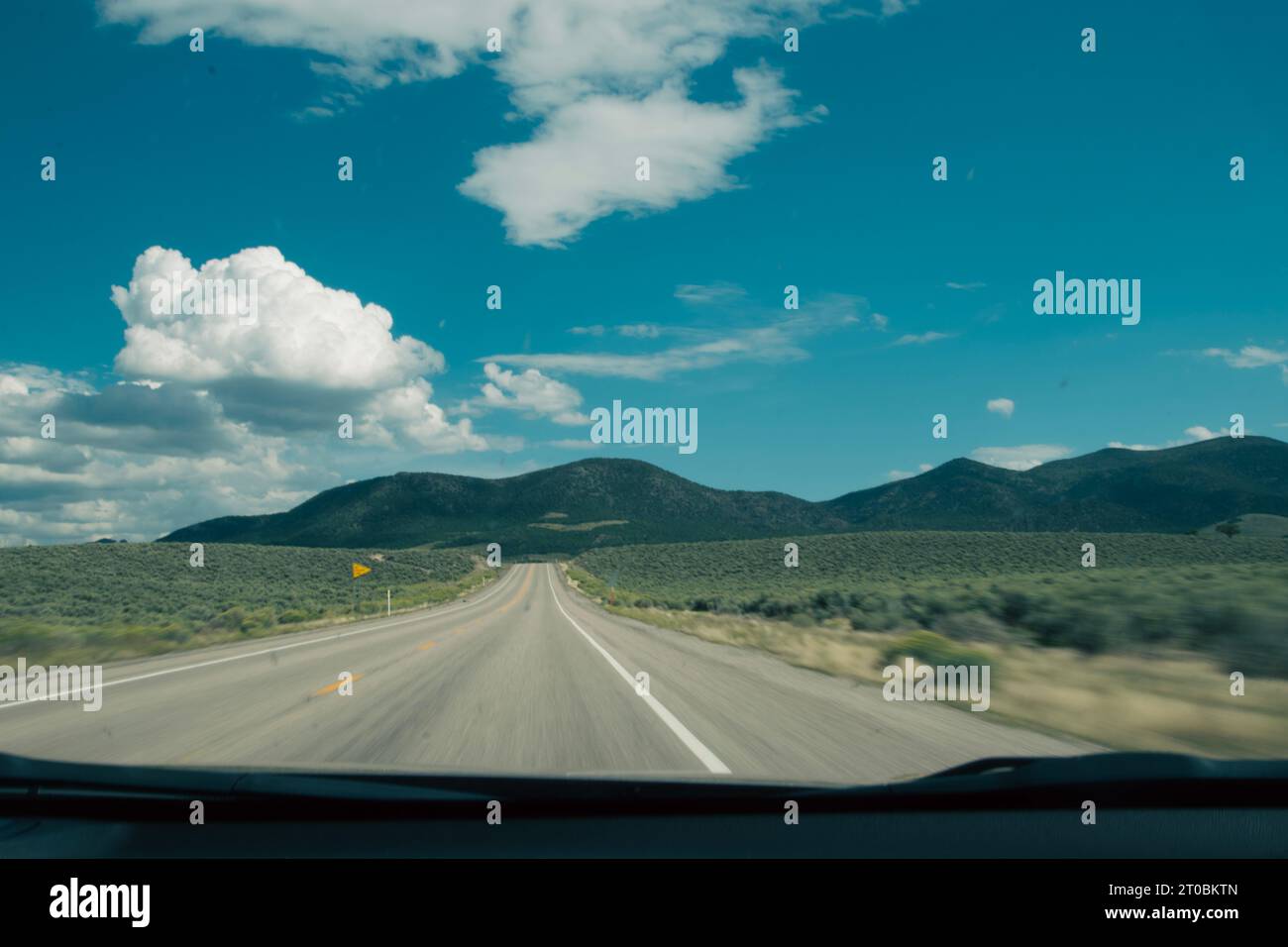 Looking out the car window at the road leading to the mountains Stock ...