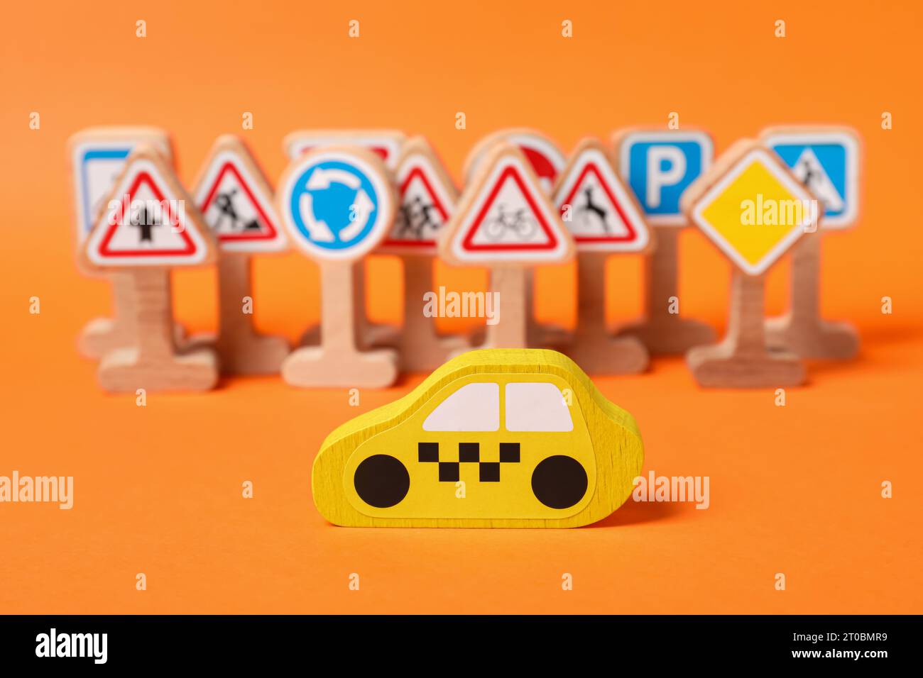 Set of wooden road signs and car on orange background. Children's toy ...