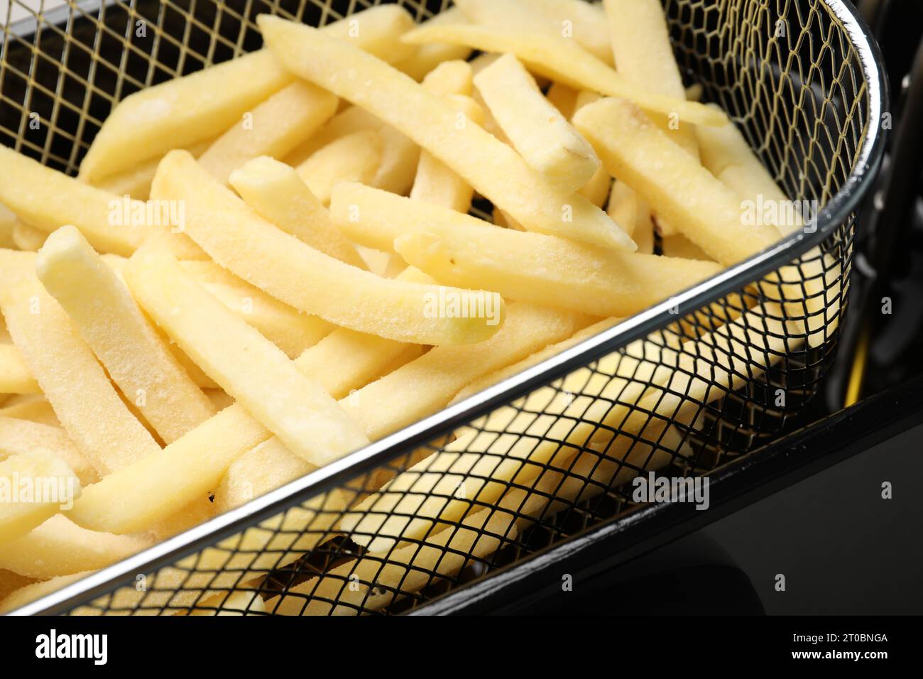 Uncooked french fries in metal basket, closeup Stock Photo - Alamy
