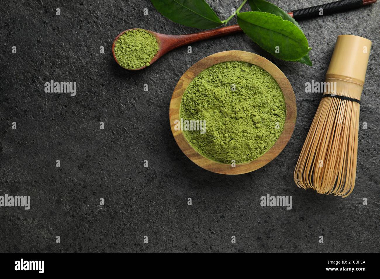 Flat lay composition with green matcha powder on grey table. Space for ...