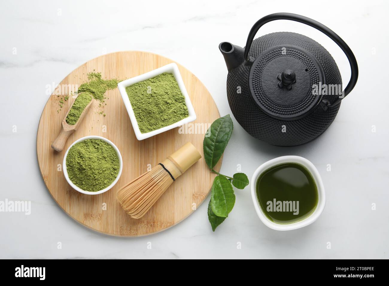 Flat lay composition with green matcha powder on white marble table ...