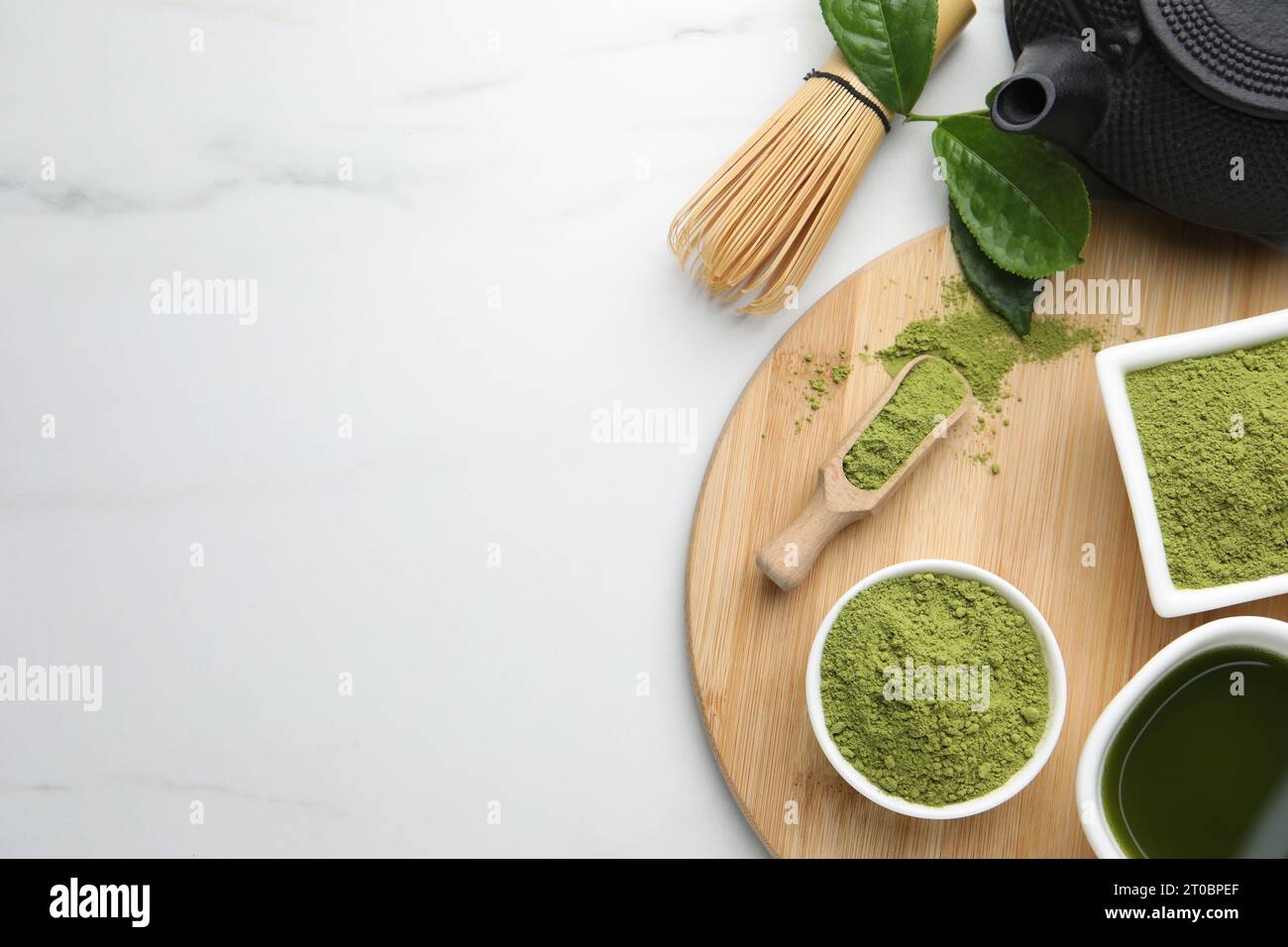 Flat lay composition with green matcha powder on white marble table ...