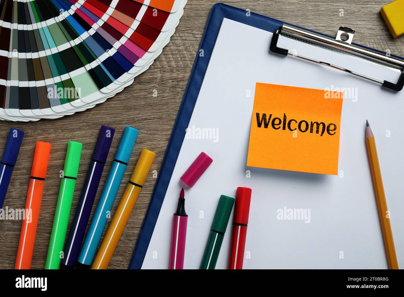 Sticky note with word Welcome, clipboard, colorful markers and palette ...