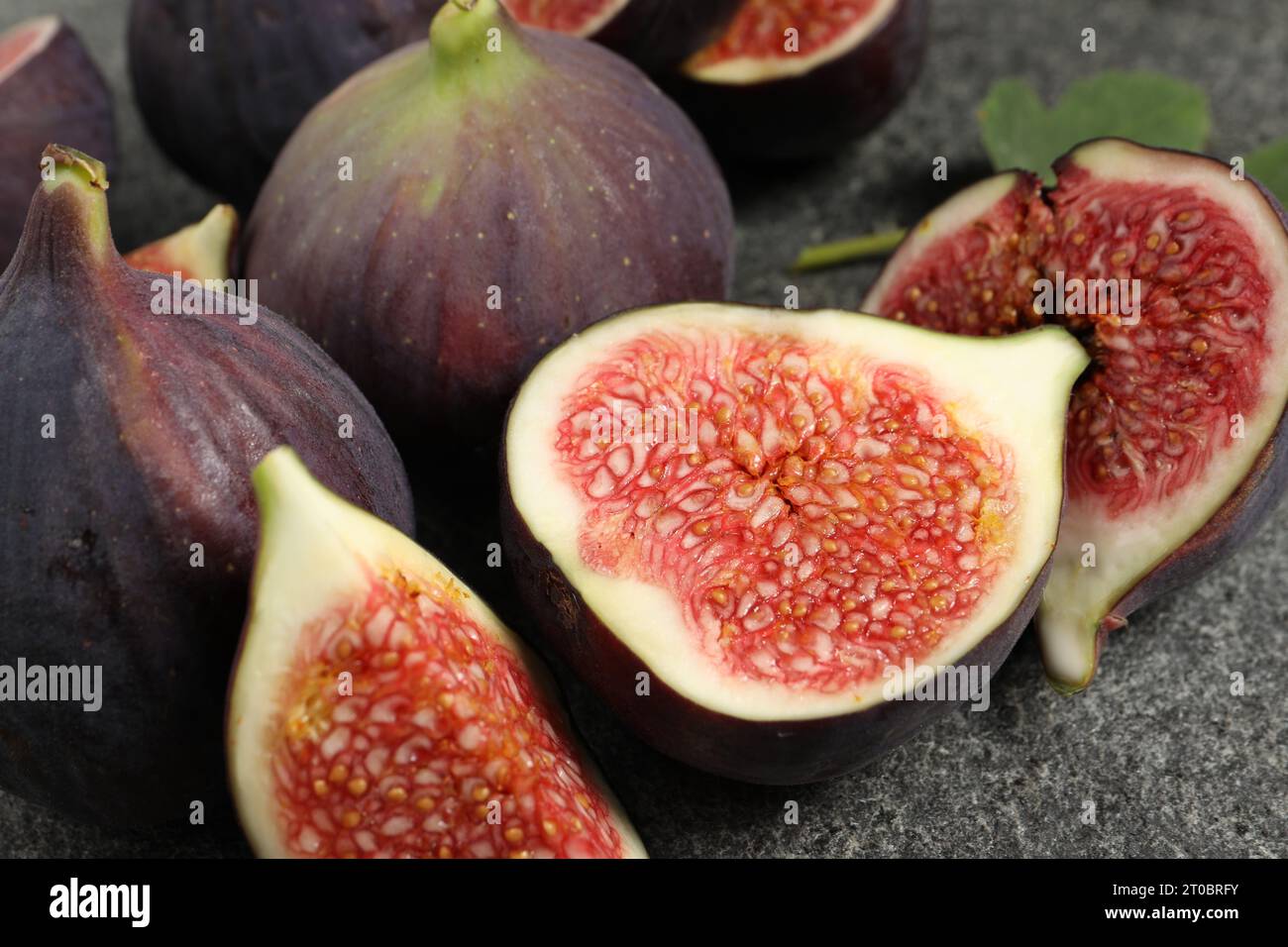 Whole and cut ripe figs on grey textured table, closeup Stock Photo - Alamy