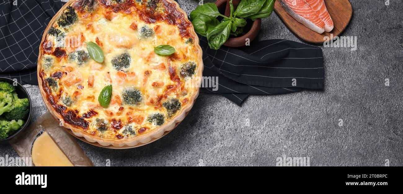 Delicious homemade quiche and ingredients on gray table, flat lay ...