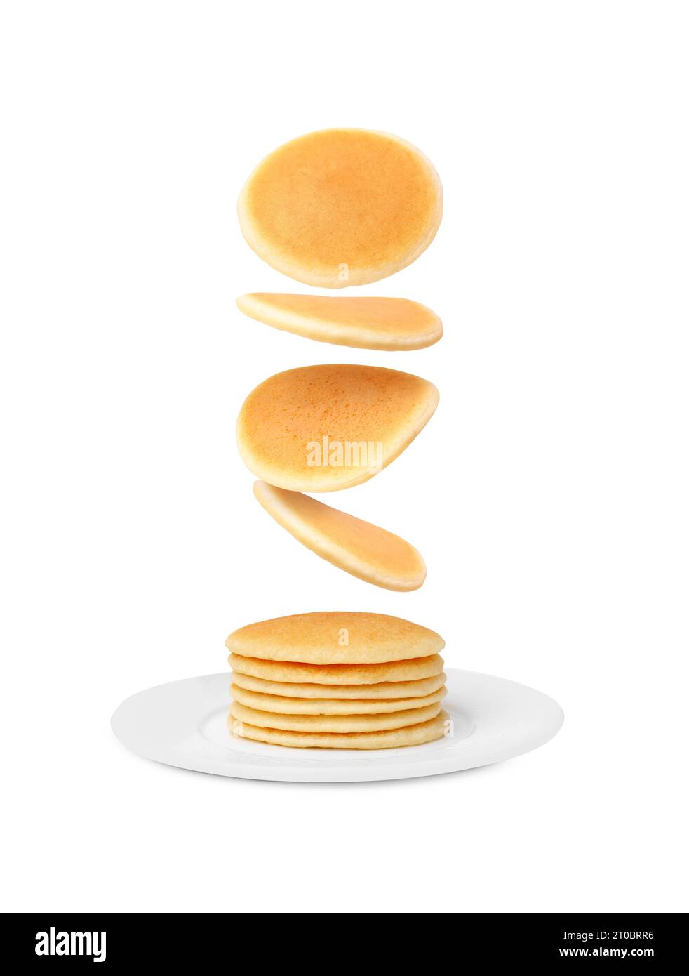 Many fresh pancakes falling onto plate against white background Stock ...