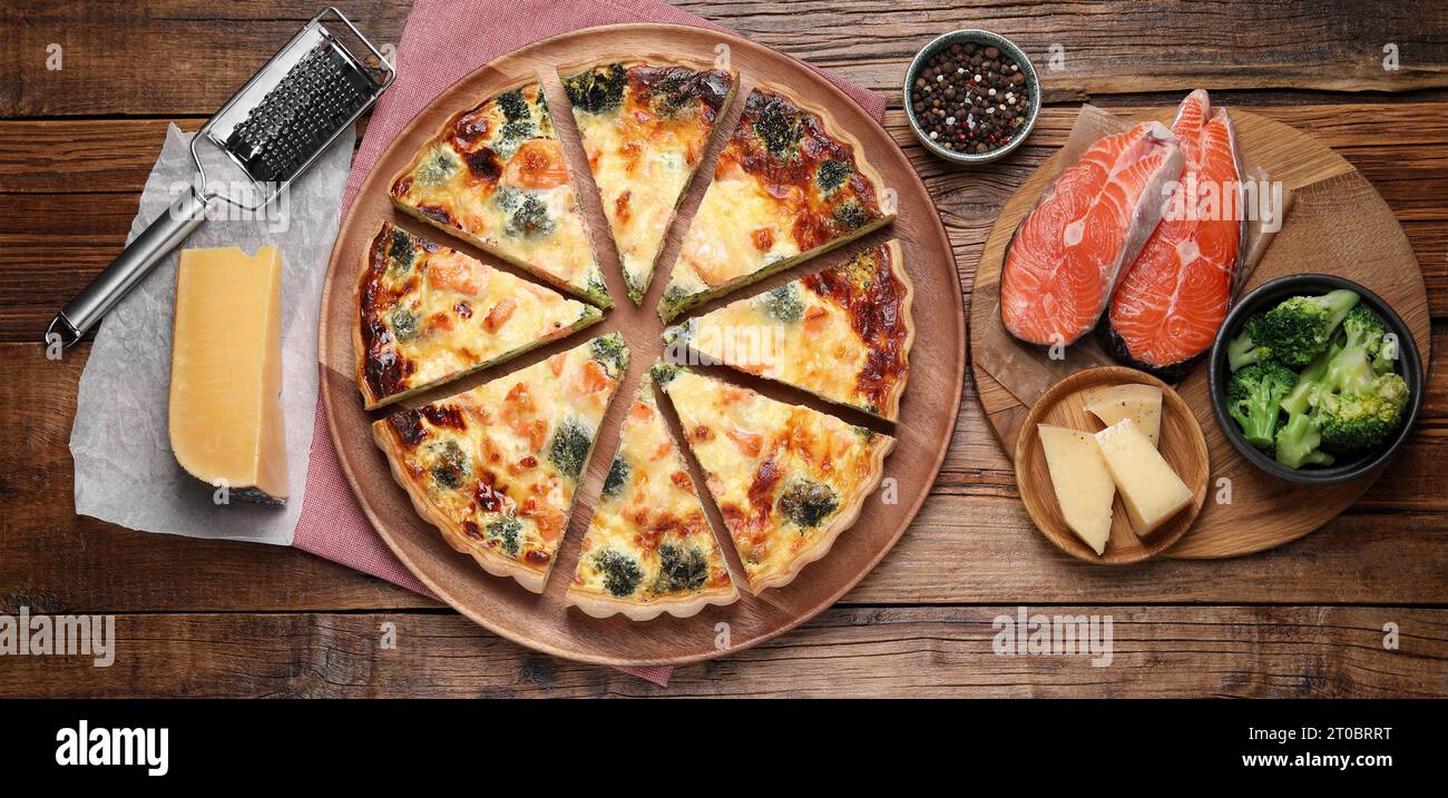 Delicious homemade quiche and ingredients on wooden table, flat lay ...