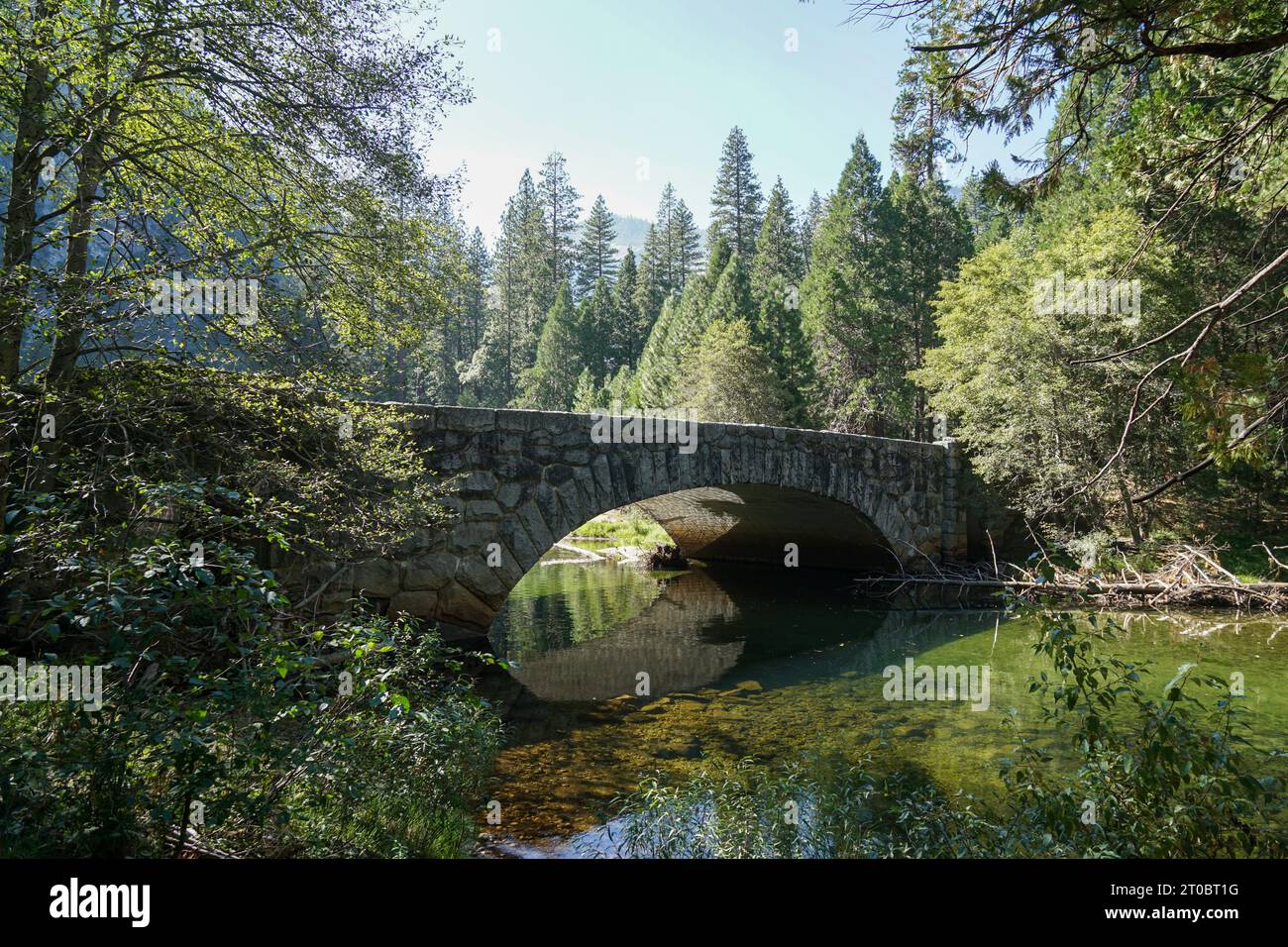 The Merced River flows under a stone bridge in the Yosemite Valley ...