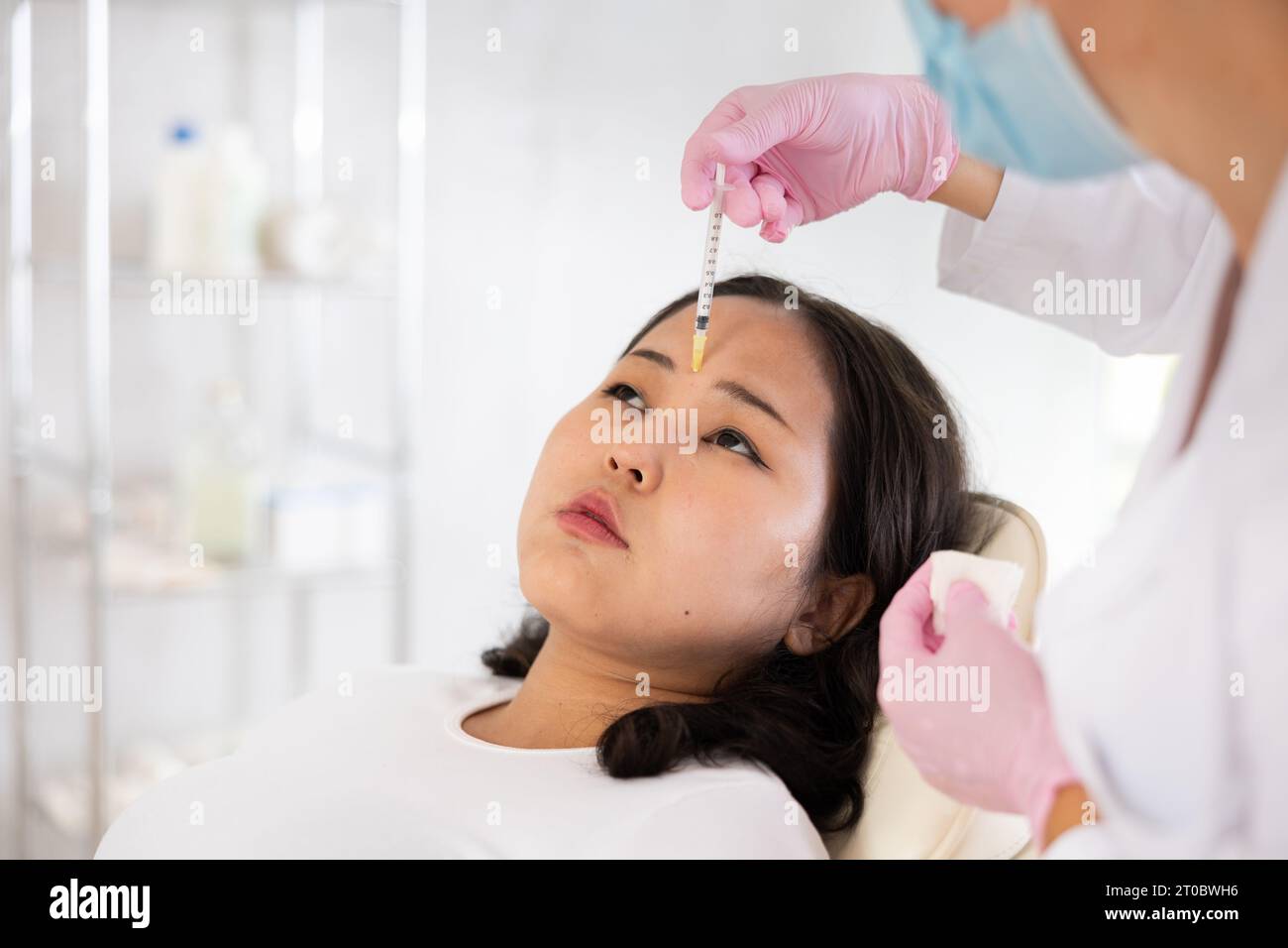Middle-aged doctor giving injection in face Stock Photo - Alamy