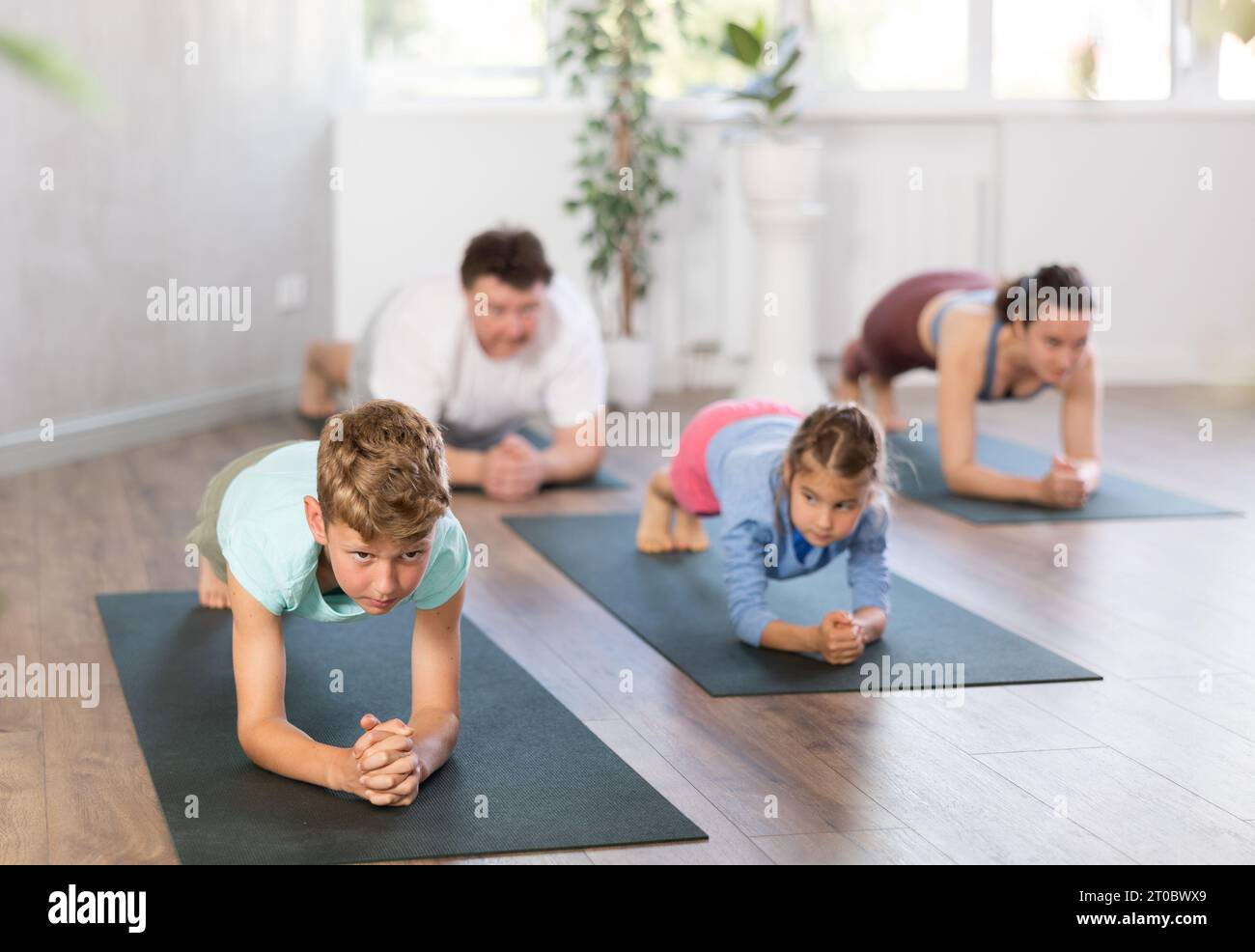 Family with two children doing pilates in studio Stock Photo - Alamy