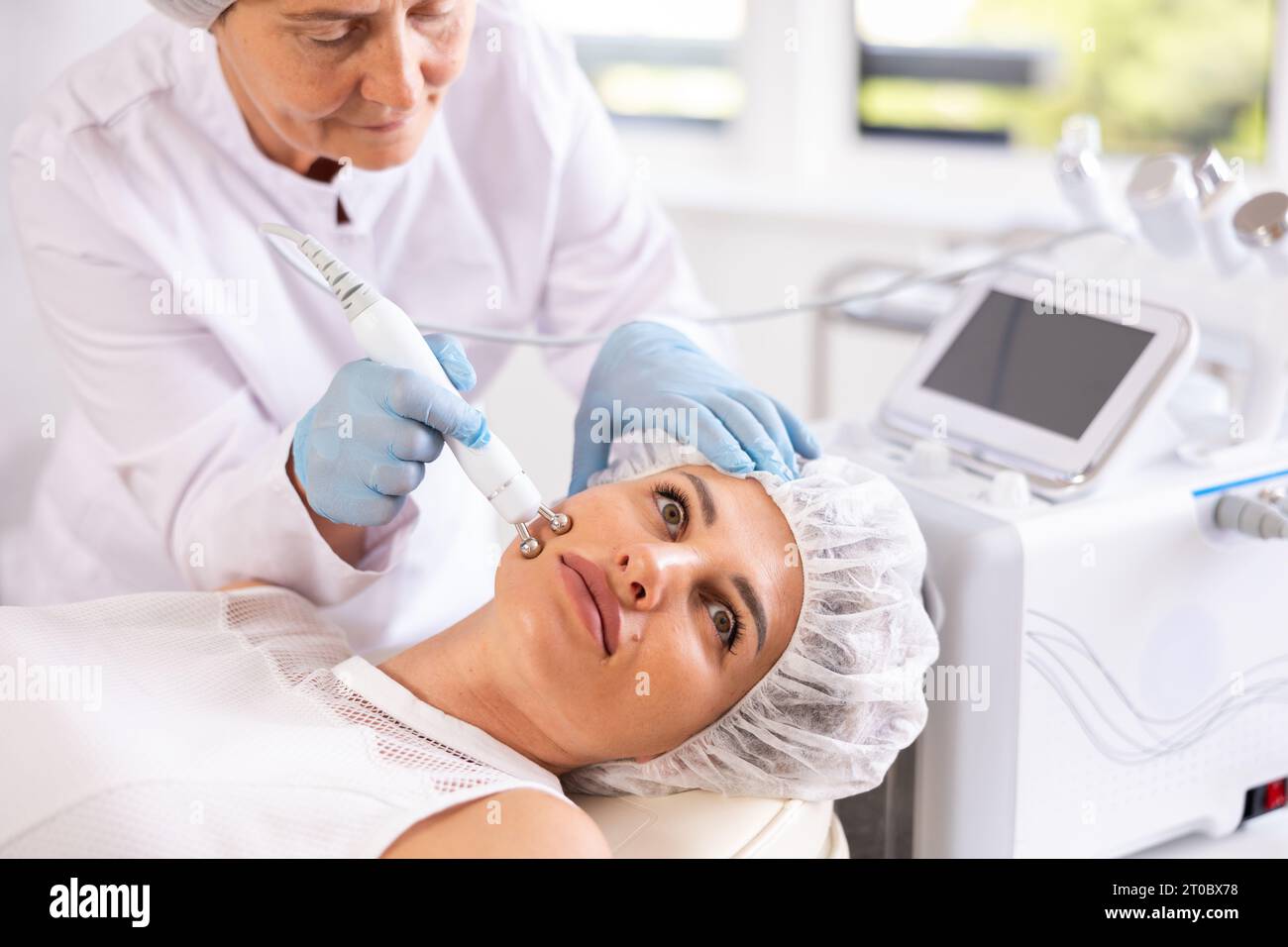 Young woman receiving facial radiofrequency procedure to tighten skin ...