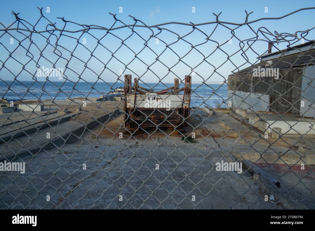 An abandoned and decaying structure tucked away securely behind a chain ...