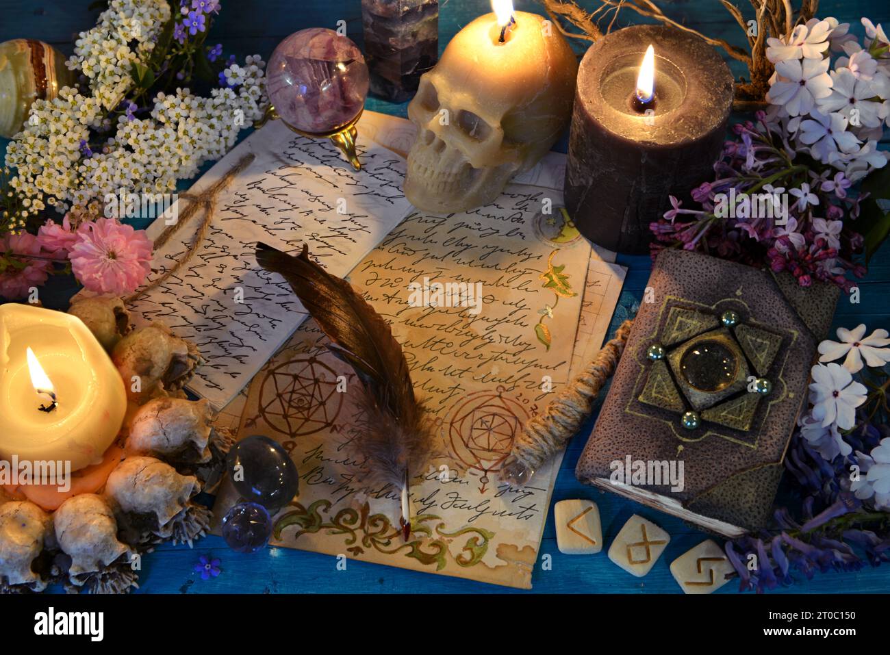 Candles, runes and manuscript with spell on witch ritual table. Occult ...