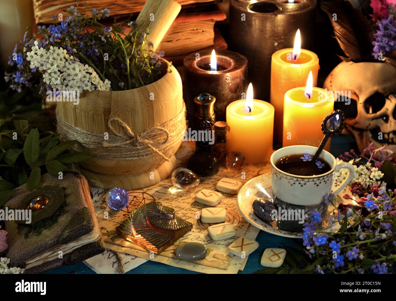 Old runes, mortar with herbs, candles and skull on witch altar table ...