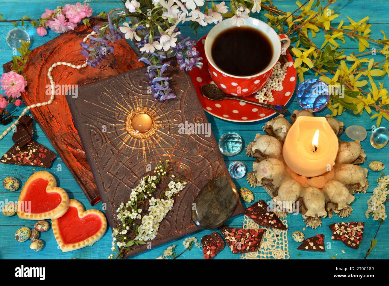 Magic book of spells with candles and cup of coffee on ritual table ...