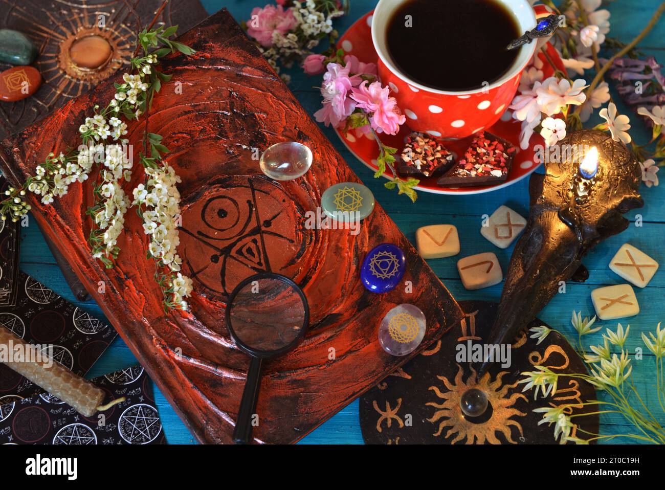 Old runes, chakras and magic book of spells with candles on witch ...