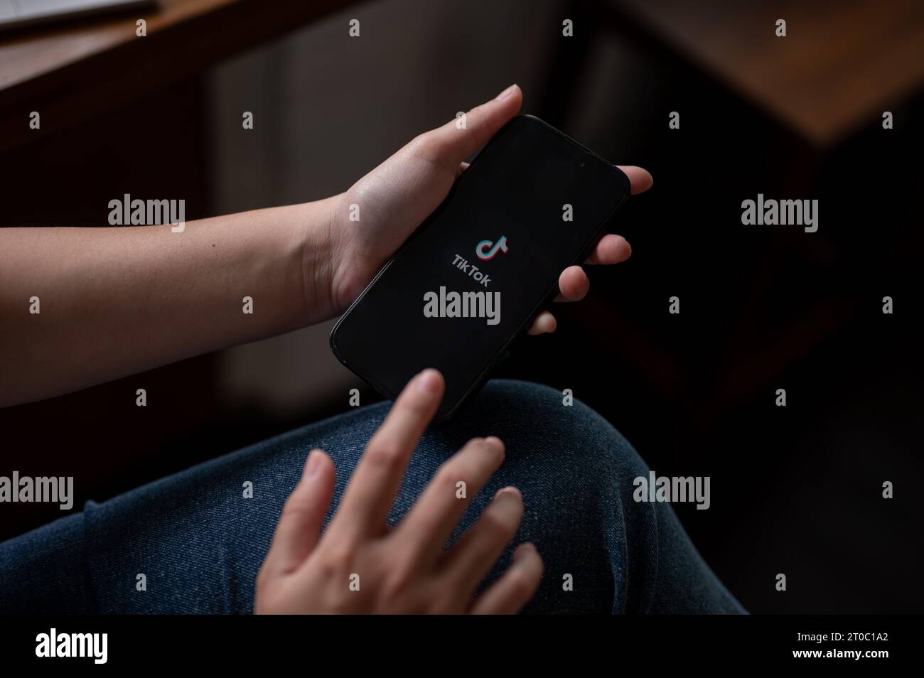 Chiang mai, Thailand - Oct 05 2023: A woman sitting indoors and using a ...