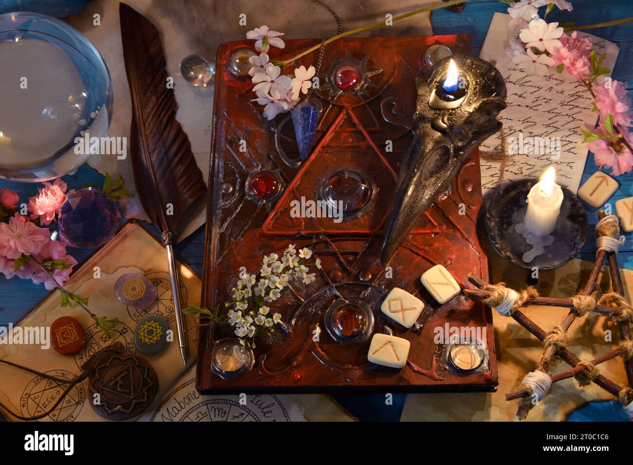 Old book of spells with runes, pentagram and candles on witch ritual ...