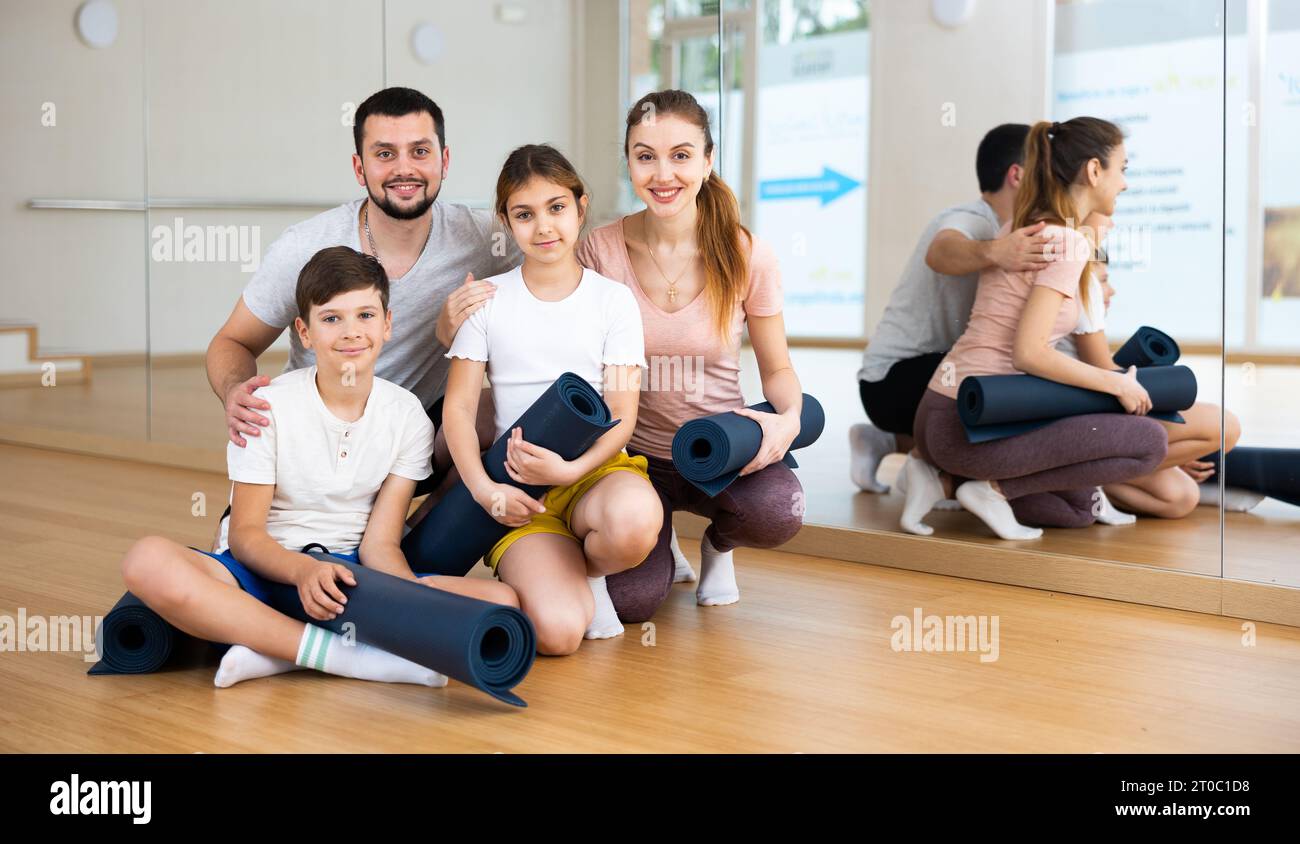 Happy family with rolled mats in gym Stock Photo - Alamy