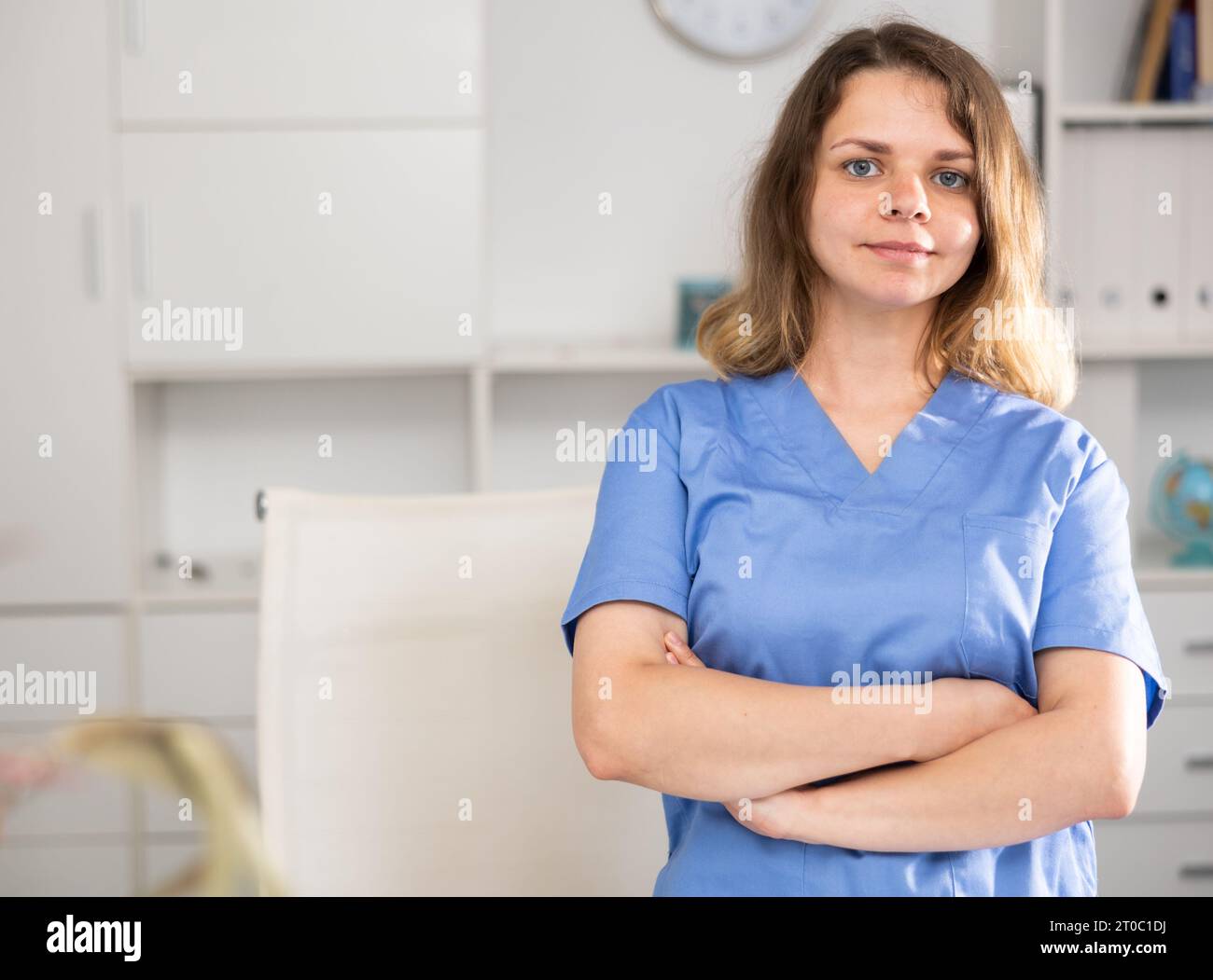 Portrait of therapist woman who is standing on her workplace in clinic ...