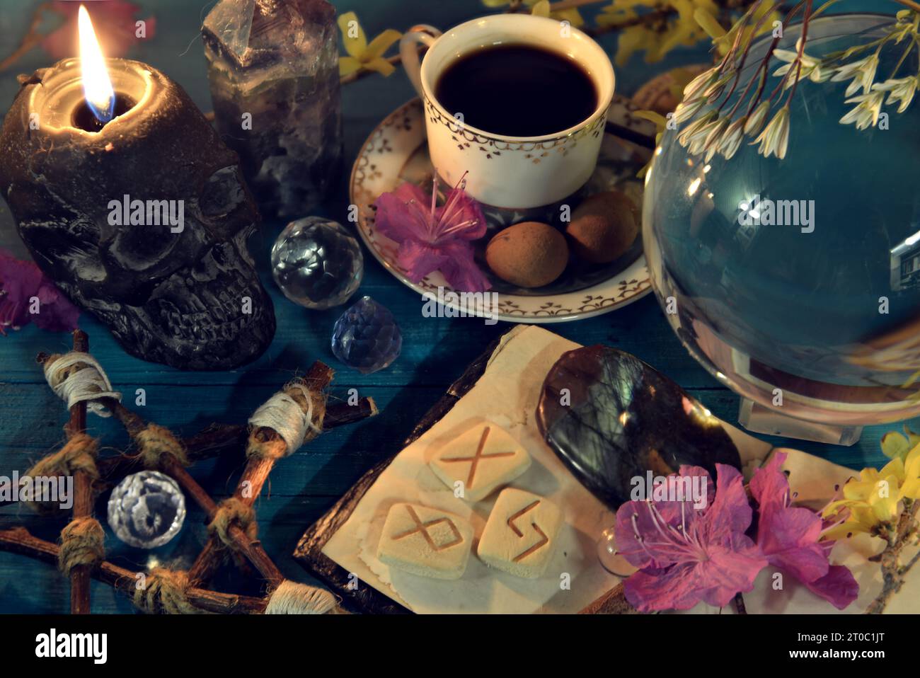 Magic crystal ball, skull candle and runes on altar ritual table ...